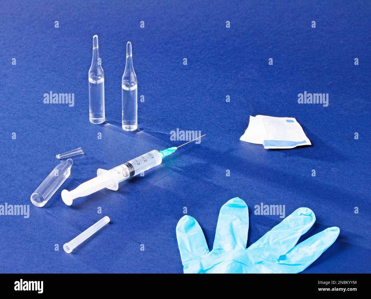 Set for injections - syringe, ampoules, and an alcohol wipe on a blue ...
