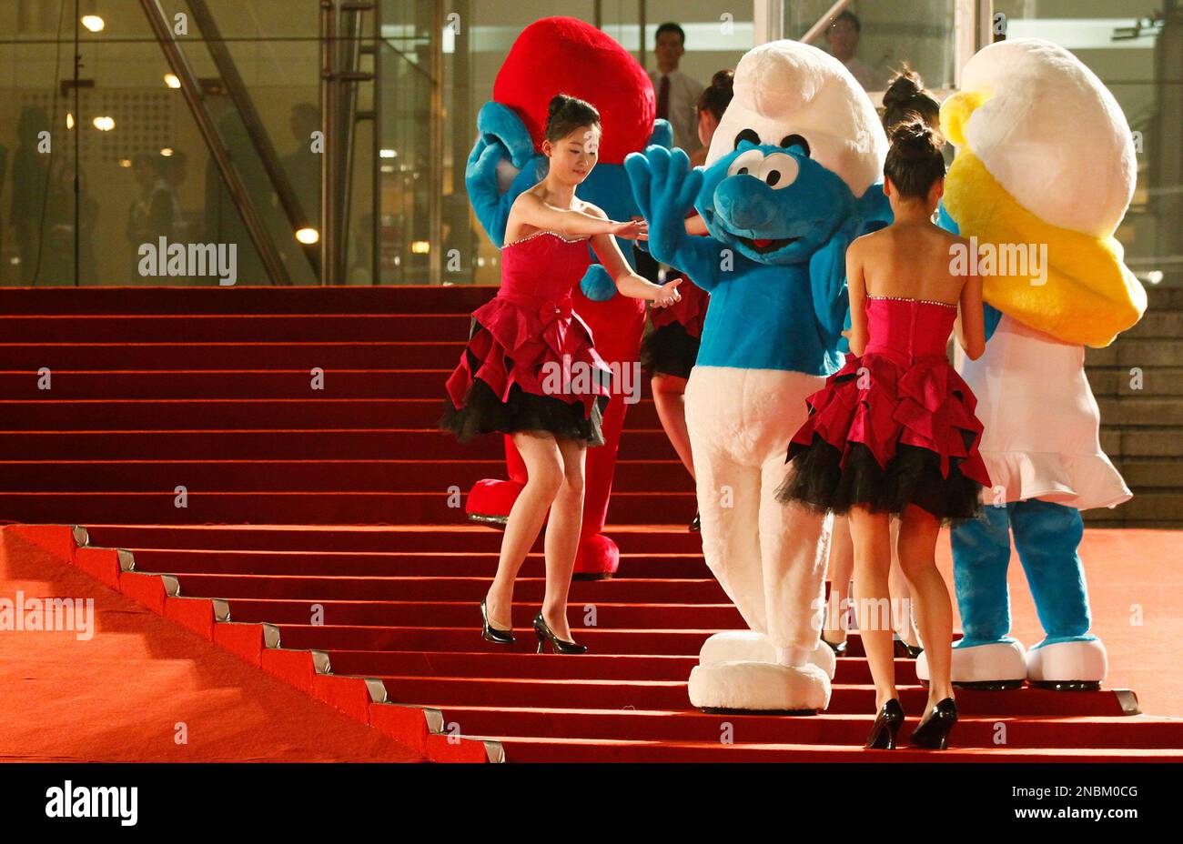 Characters of the film "The Smurfs" are escorted by hostesses on the ...