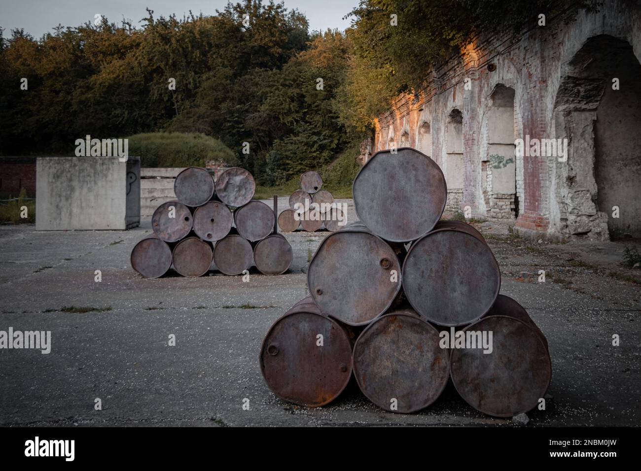 The rustic metallic barrels on the ground near an arch bridge Stock ...