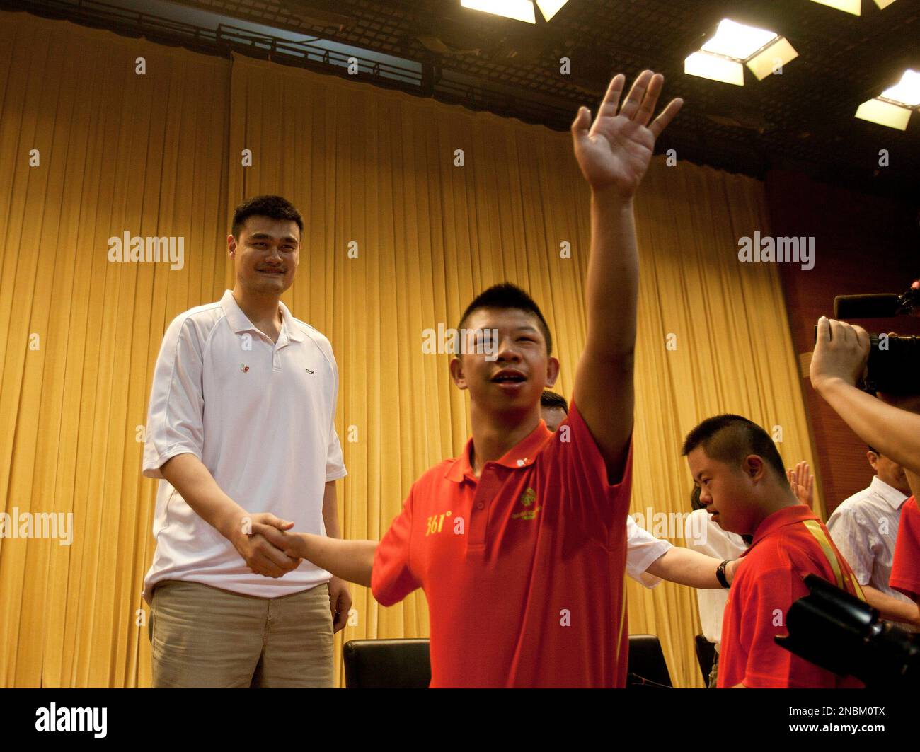 A Chinese disabled athlete waves while shaking hands with Houston ...