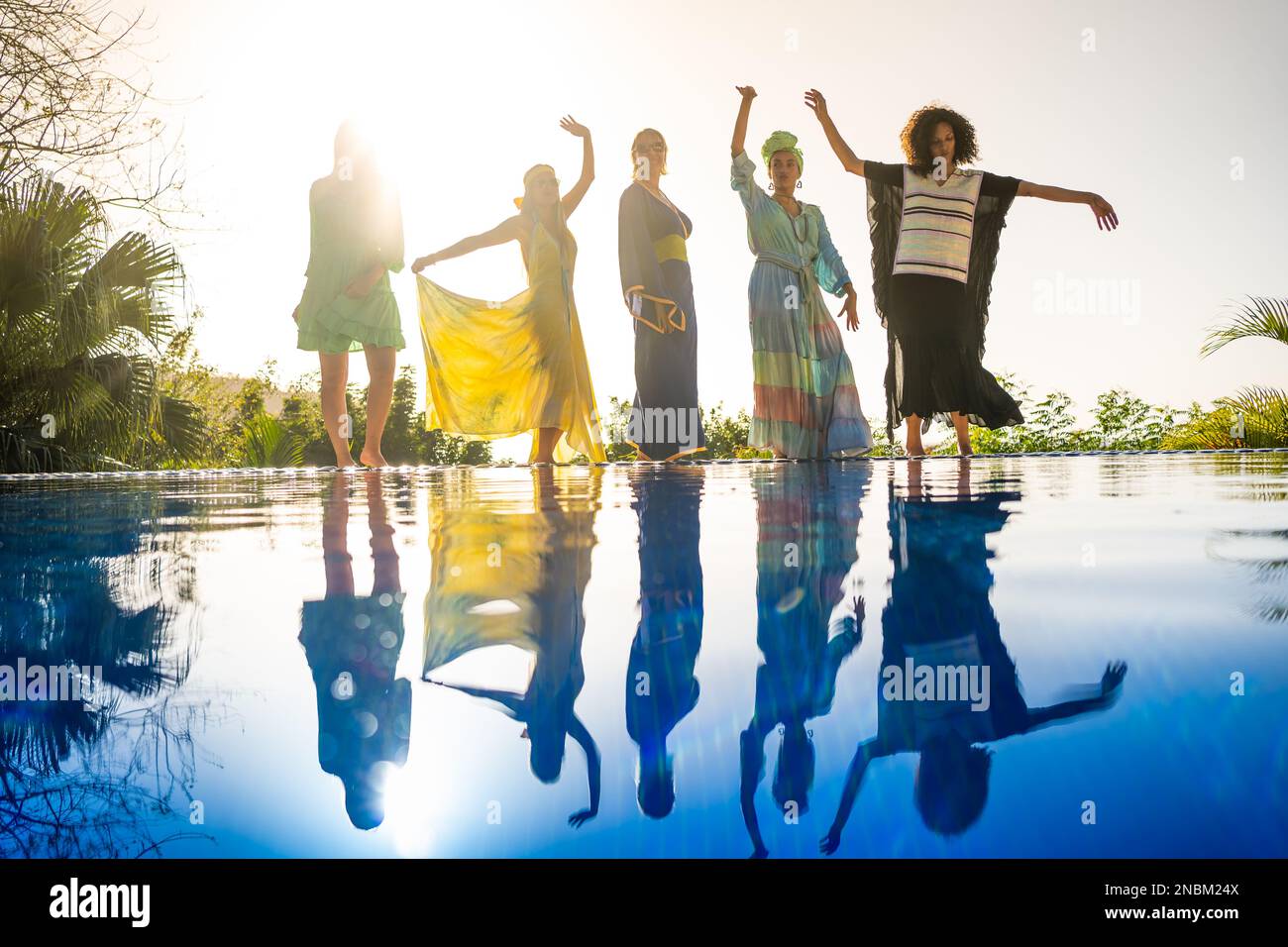 Group of beauty models on the edge of an outdoor swimming pool Stock ...