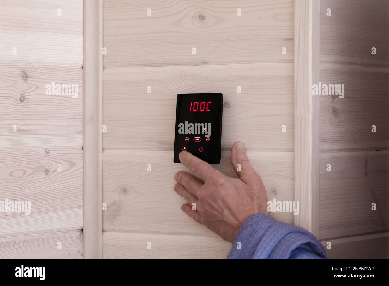 male hand adjusts the temperature in the sauna on the touchscreen of ...