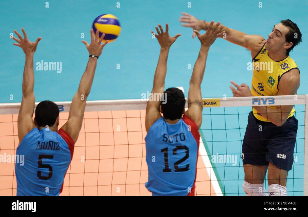 Brazil's Giba spikes the ball against Puerto Rico's Roberto Muniz, left ...