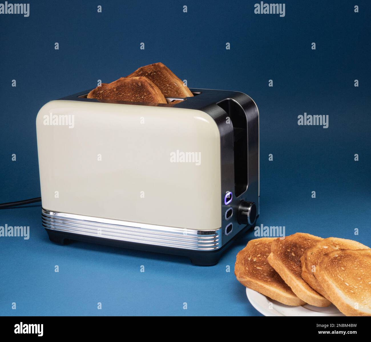 toaster with cooked toasts on a blue background Stock Photo - Alamy