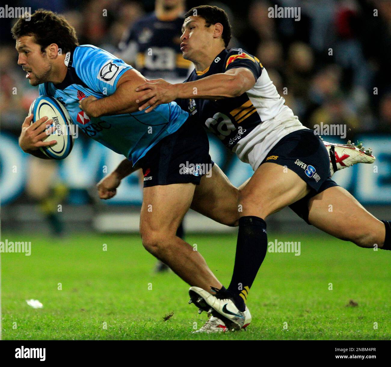 The Waratahs' Chris Alcock, left, dives toward the try line as the ...