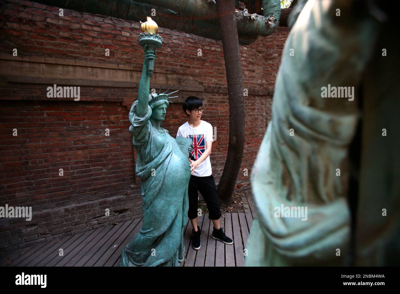 A Chinese man touches the swollen belly of a Statue of Liberty ...
