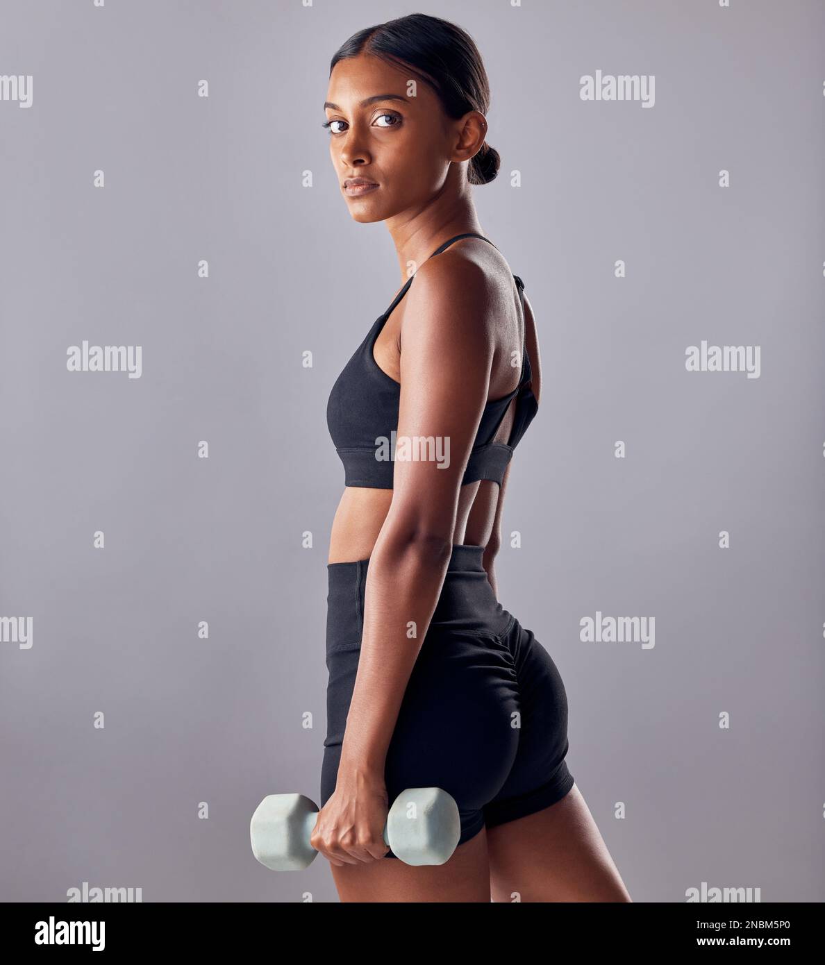 Woman, focus portrait and dumbbell in studio for strong body, wellness ...
