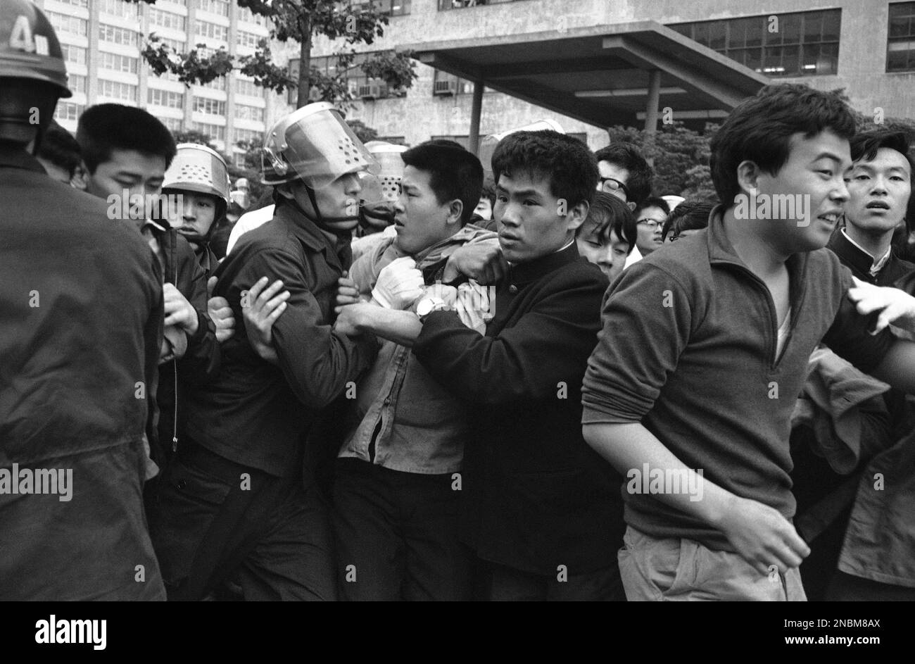 Leftist student demonstrator and helmeted riot policeman as police push ...