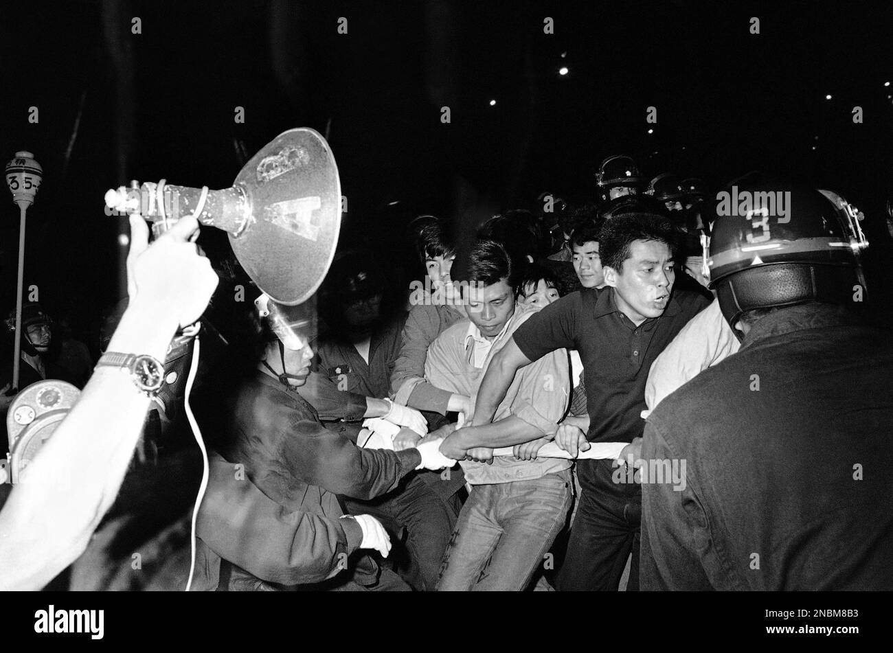 A Japanese riot policeman struggles with Zengakuren students during an ...