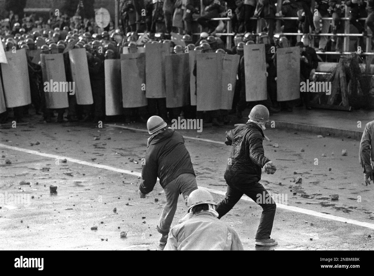 Leftist students, foreground, throw rocks at riot police who hold ...