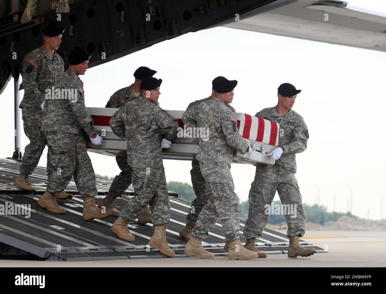An Army carry team moves a transfer case containing the remains of Pvt ...