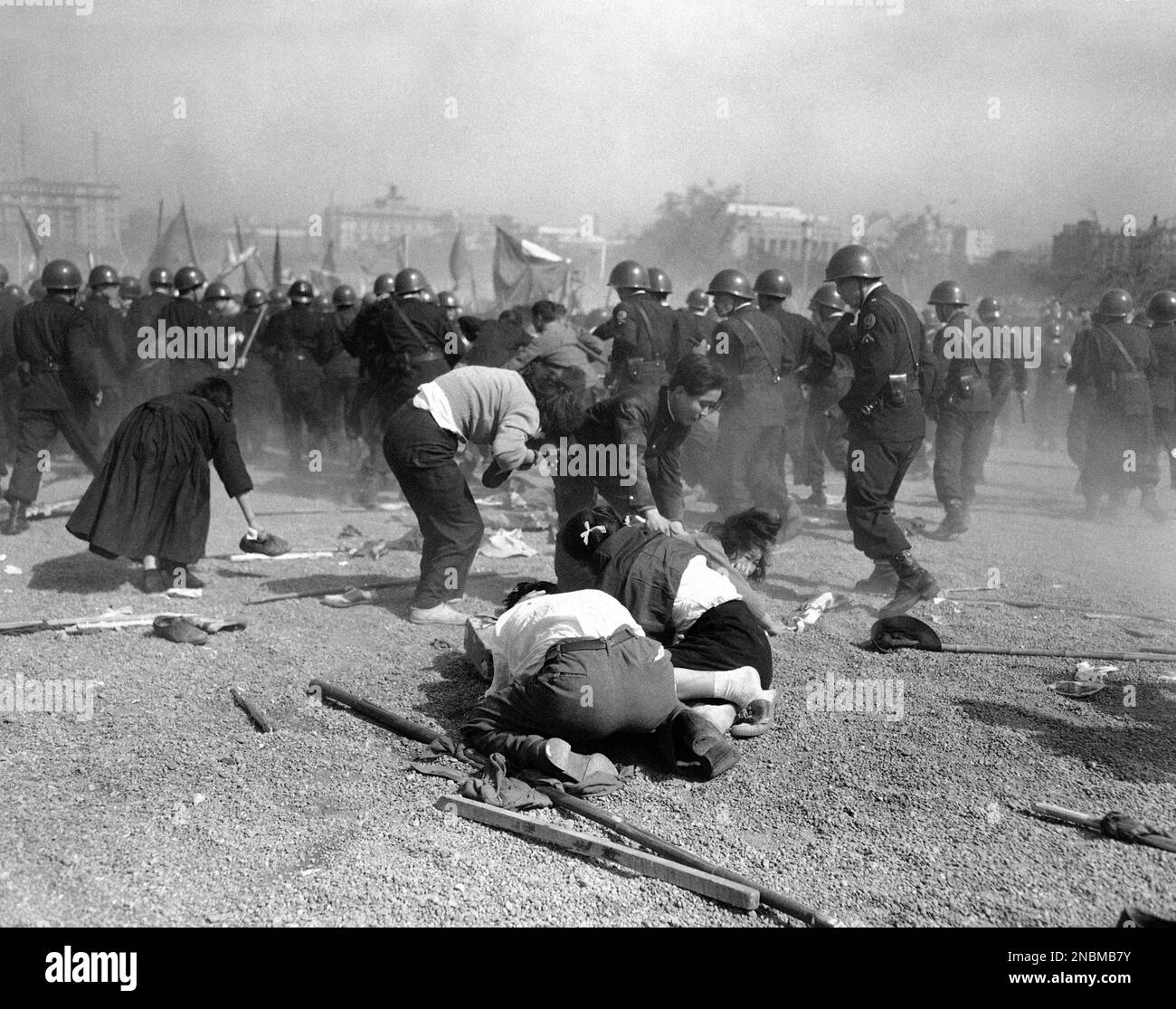 Japanese police swirl past Japanese injured during the riots in Tokyo ...