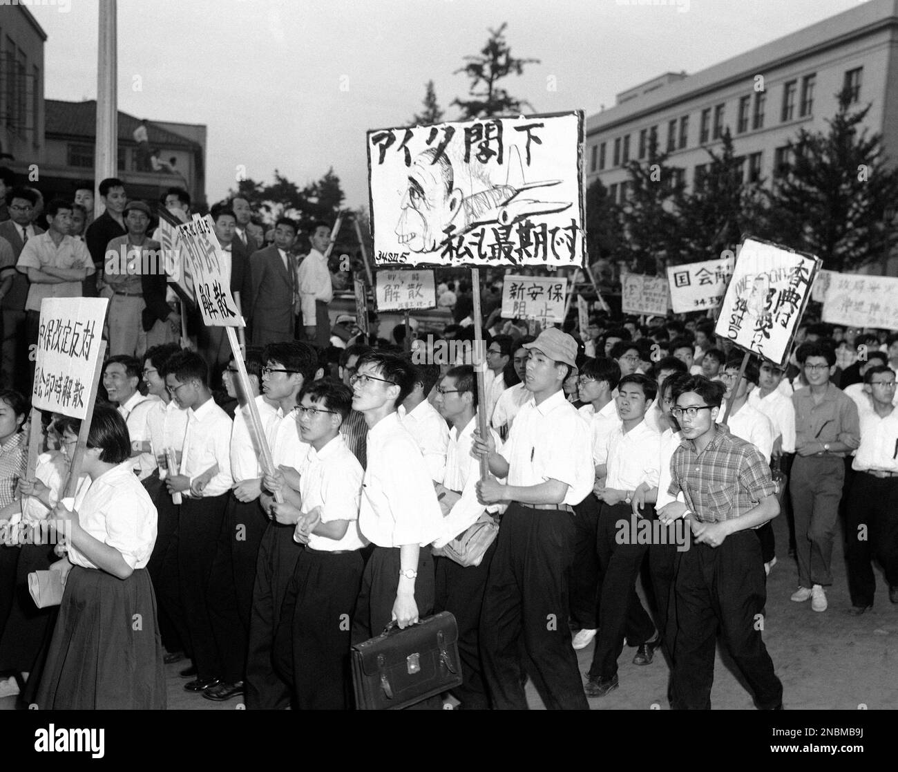 Sign-carrying demonstrators snake dance in front of the official ...