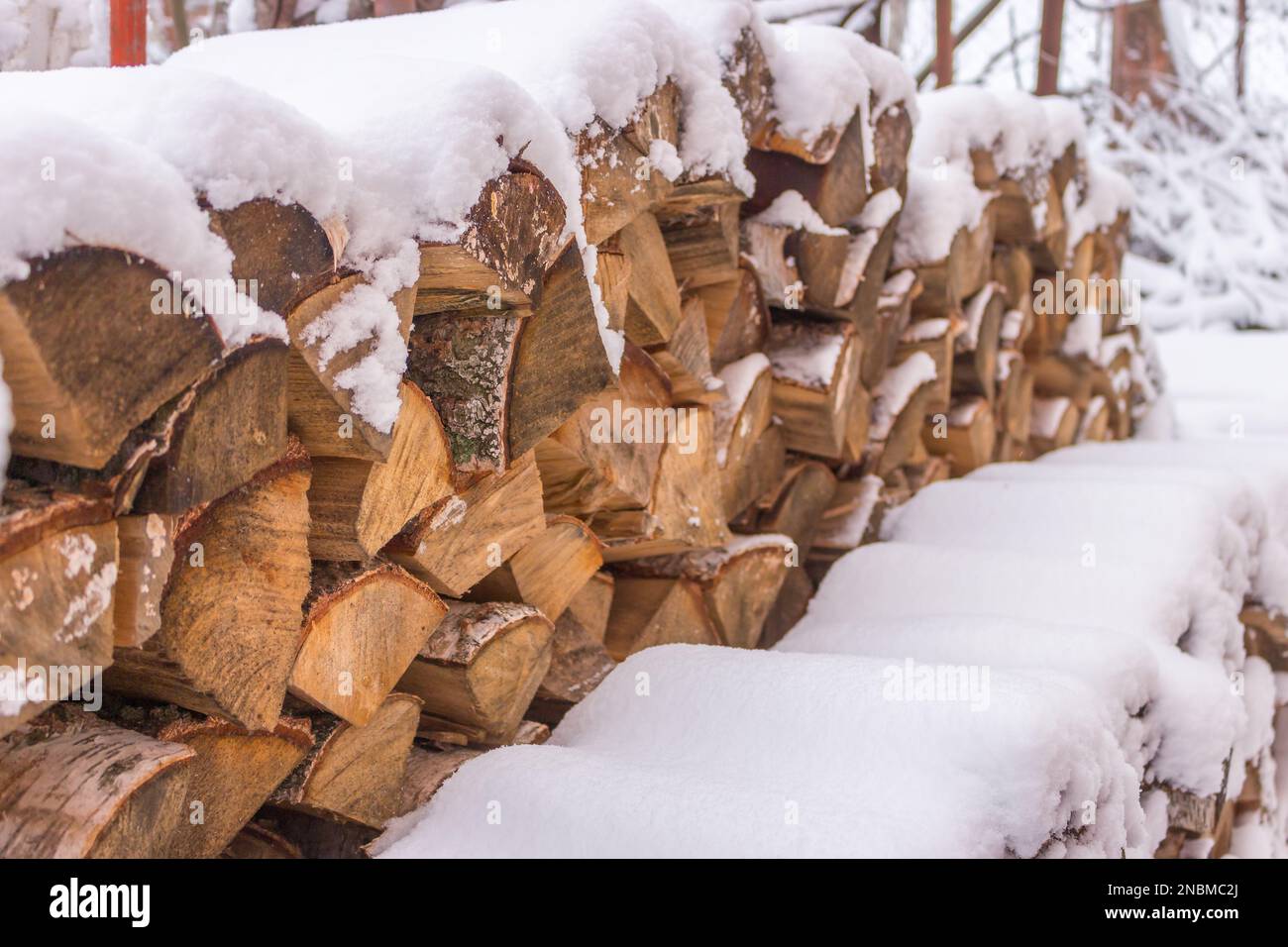 Snow covering logs. Chopped wood under snow. Hardwood on snowy backyard ...