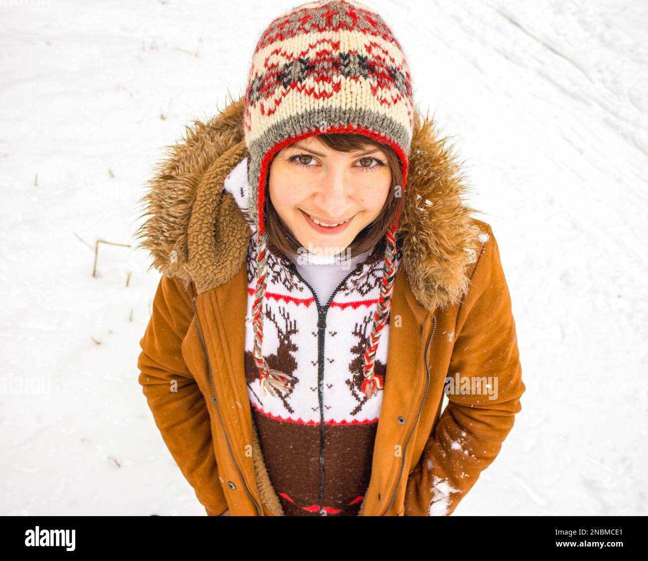 Smiling young girl in knitted cozy wear in snowy winter forest. Winter ...
