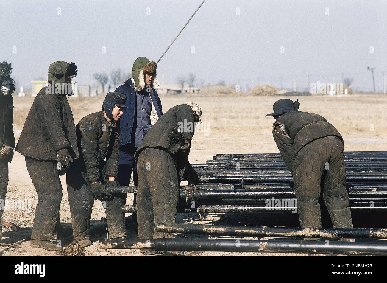 Repair team working on pipes in the Sleng Li (Victory) oilfield in ...