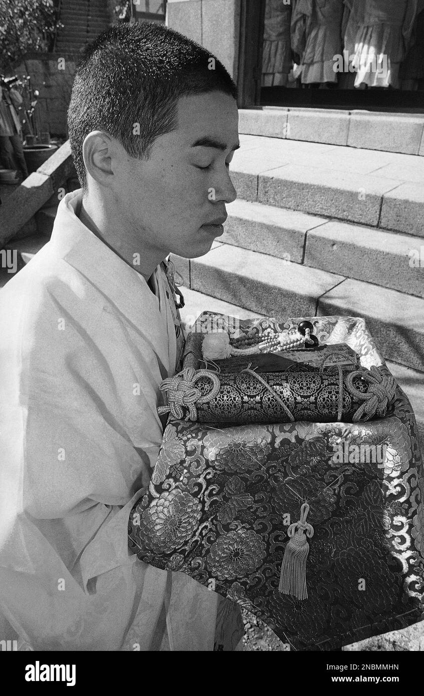 Buddhist acolyte holds ceremonial objects for use by ascetic priest in ...