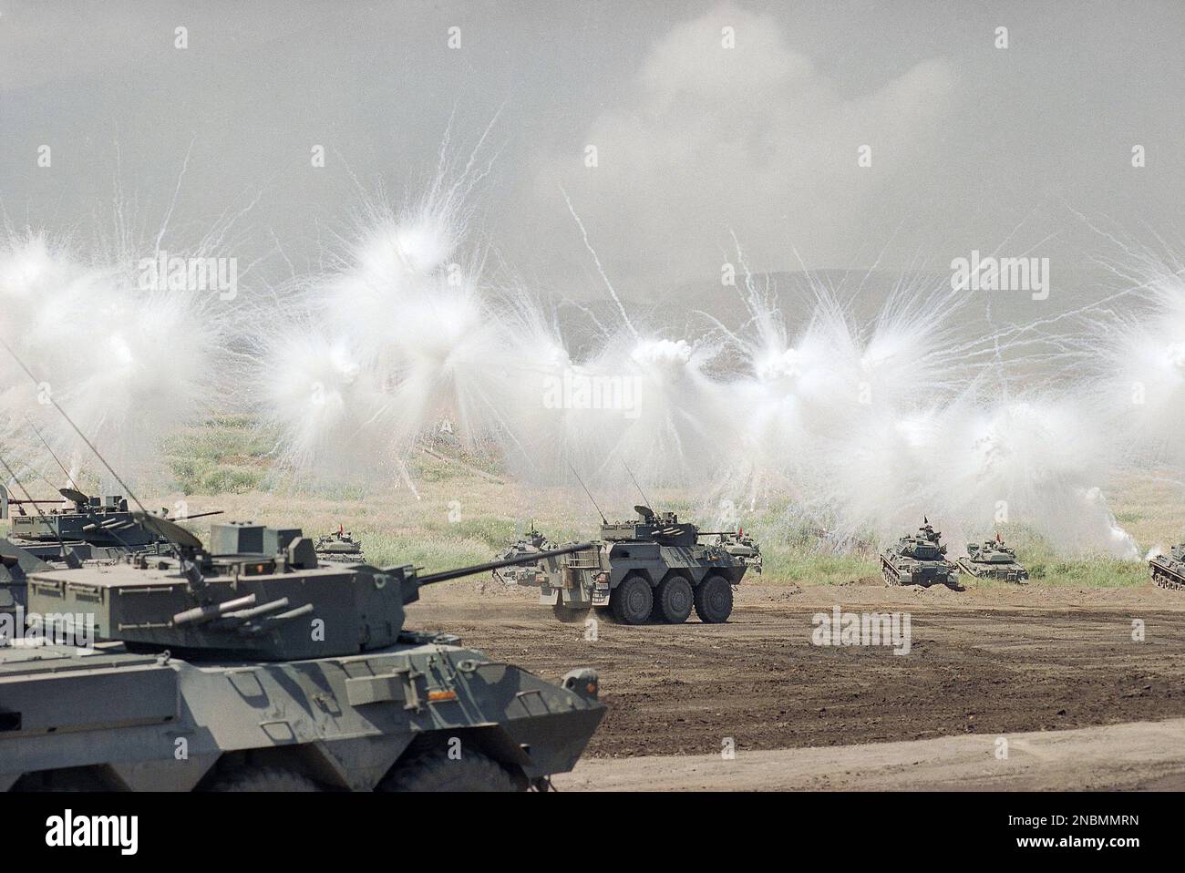 Army vehicles of the Japanese Army rumble ahead across the field under ...