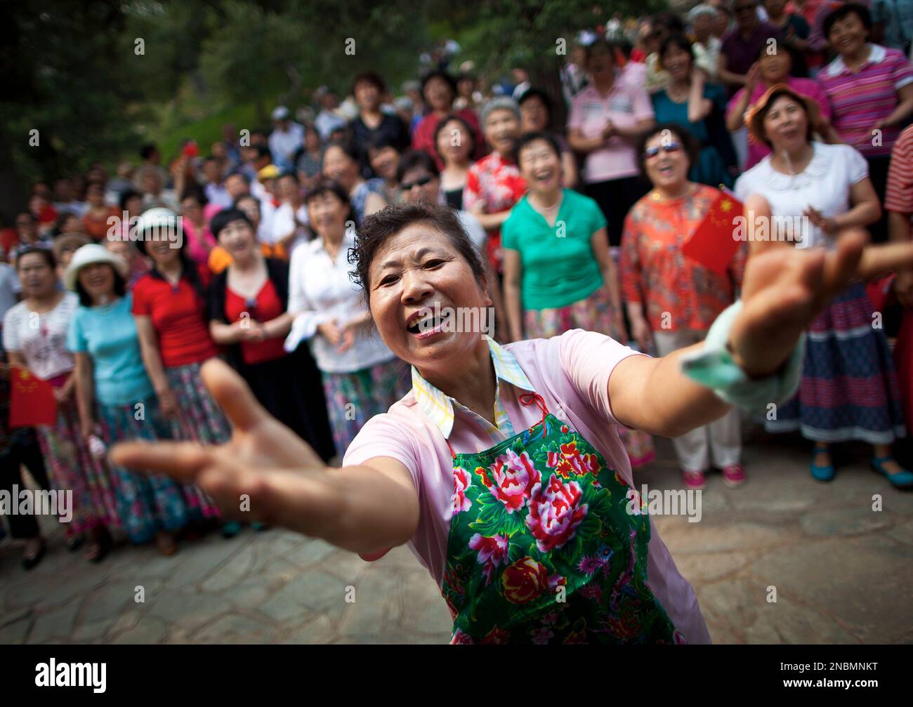 A Chinese woman performs as others sing patriotic songs to celebrate ...