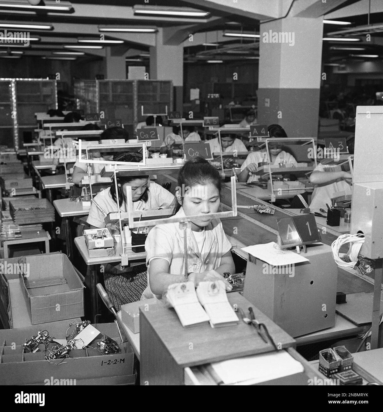 Girls assembling midget transistor radios in a clean Sony factory in ...