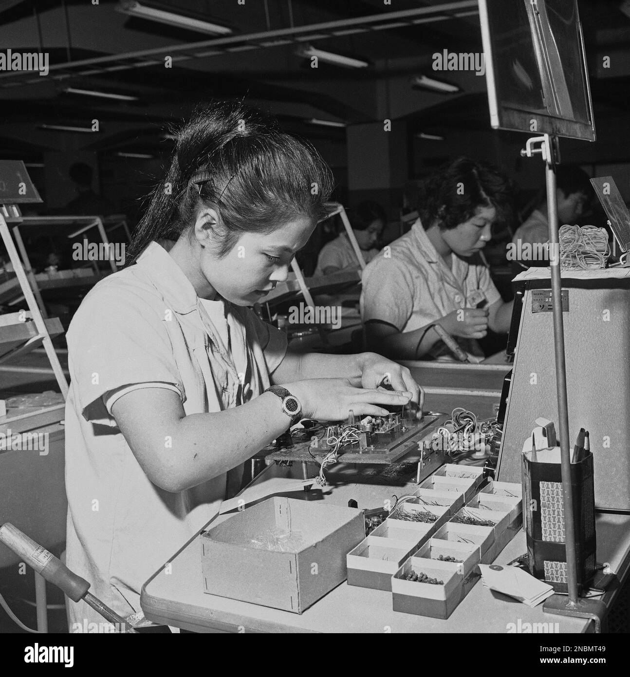 Girls assembling midget transistor radios in a clean Sony factory in ...