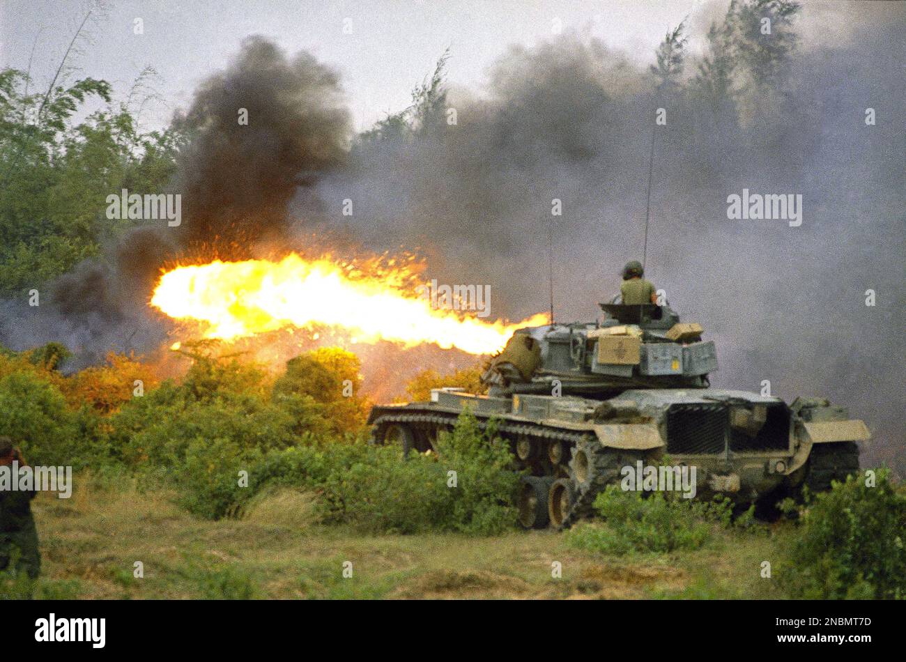 U.S. Marine tank fires flame thrower into a thicket in Vietnam in an ...