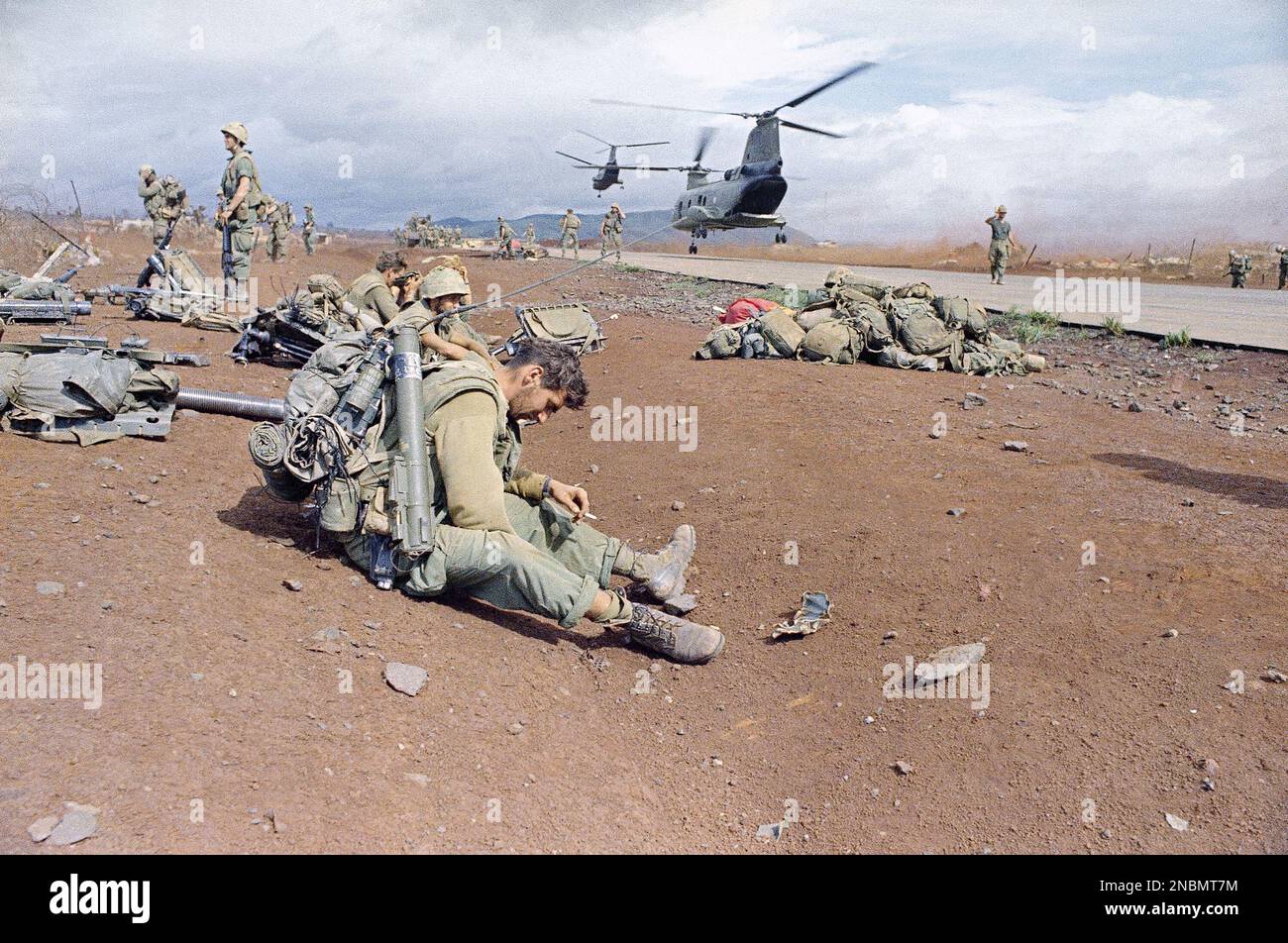 Tired Marines wait for airlift by helicopter from landing strip along ...