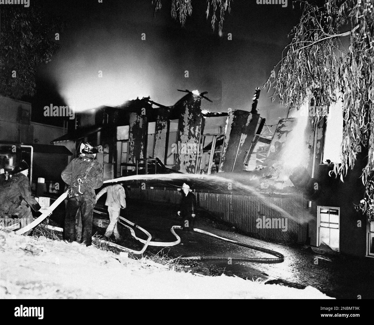 Firemen throw a stream of water on the burning Atomic Energy Commission ...
