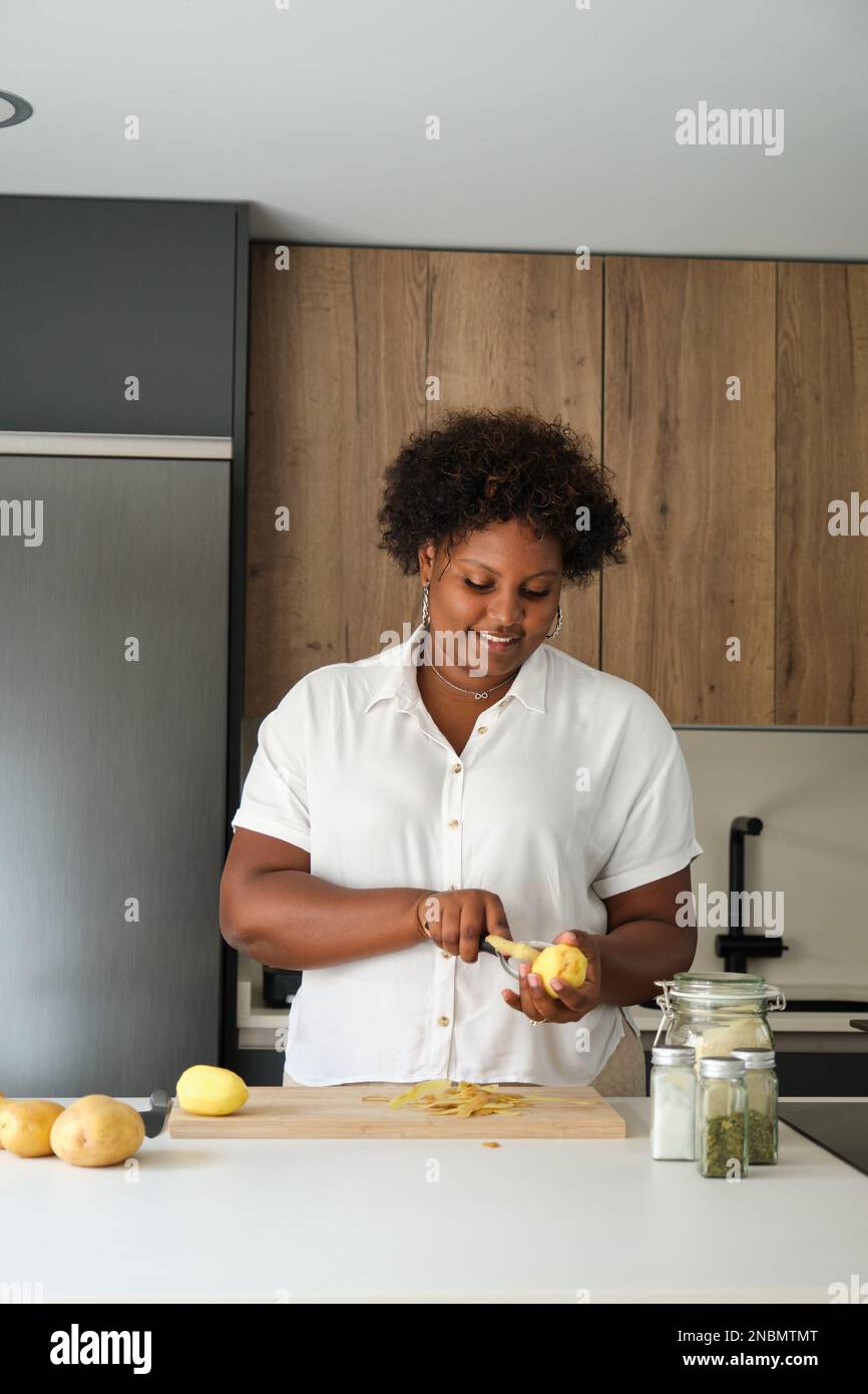 Young cuban woman peeling a raw potato Stock Photo - Alamy