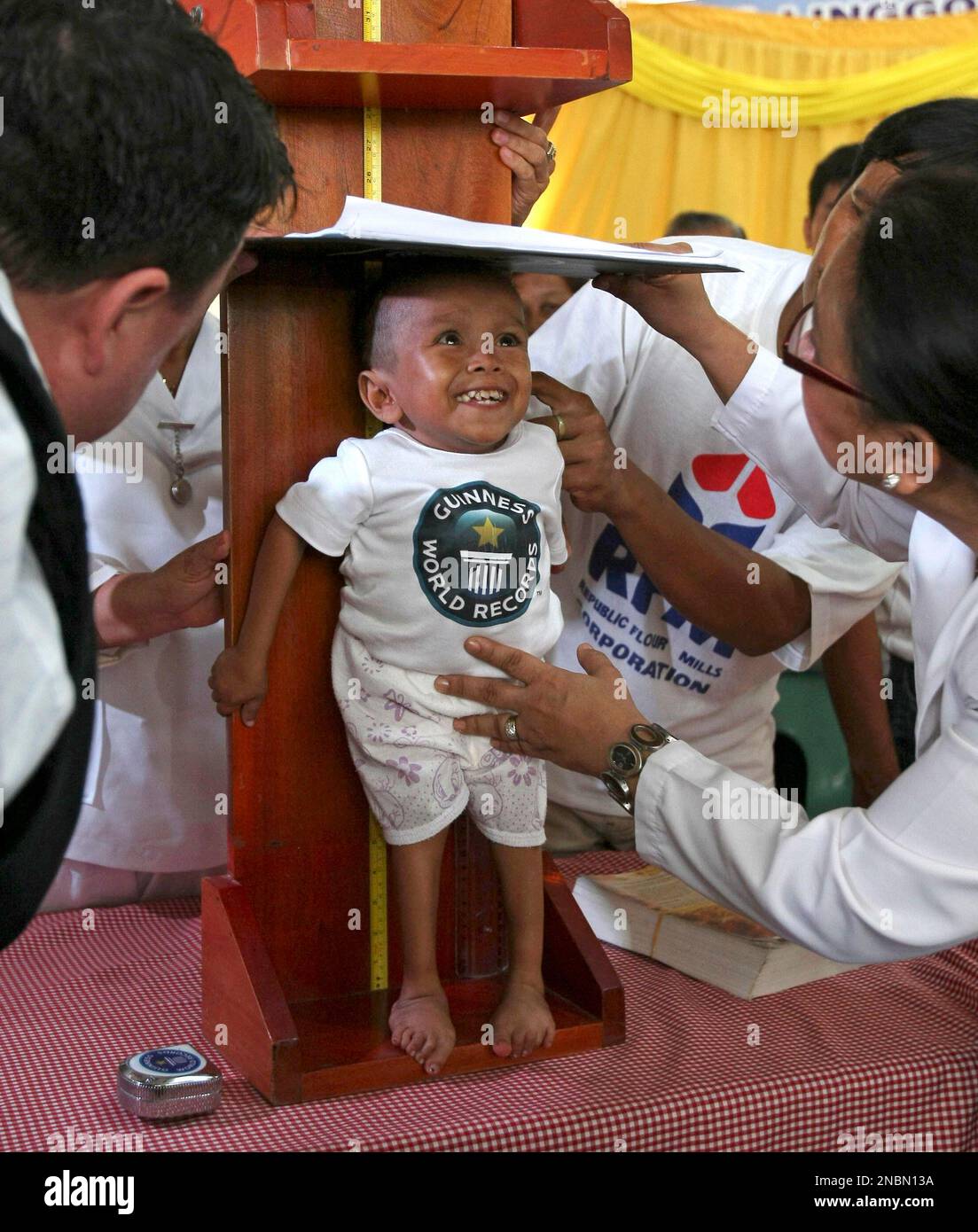 Junrey Balawing, center, smiles as he is measured by Guinness World Records adjudicator Craig ...