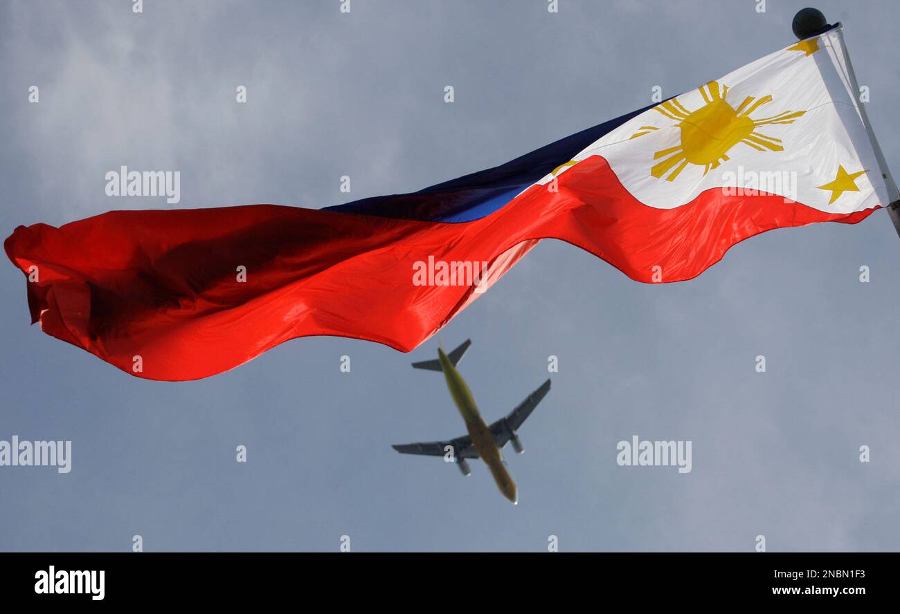 A plane passes by the Philippine flag at the historic Emilio Aguinaldo ...