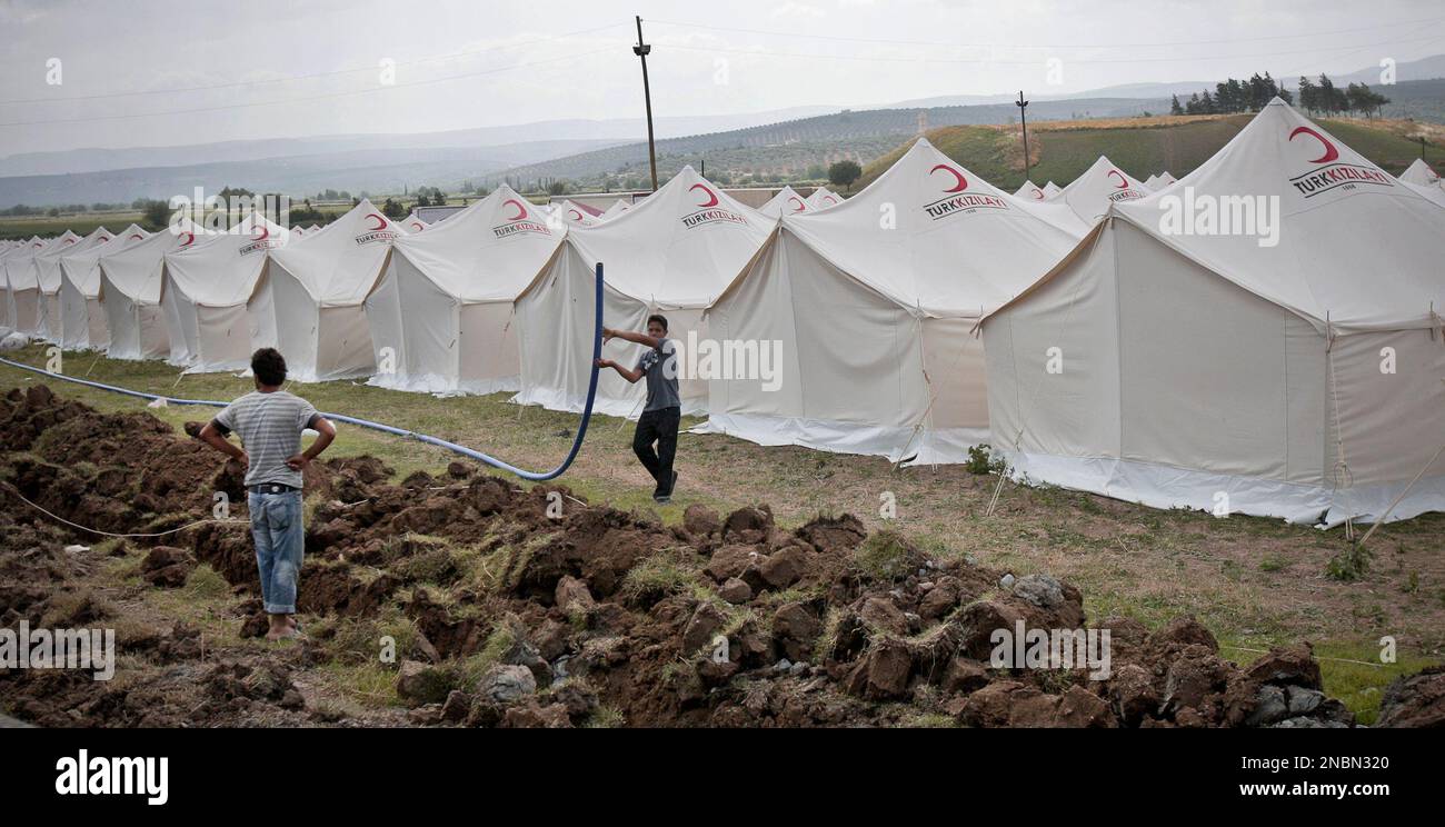 Turkish Red Crescent workers install power lines into an almost ...