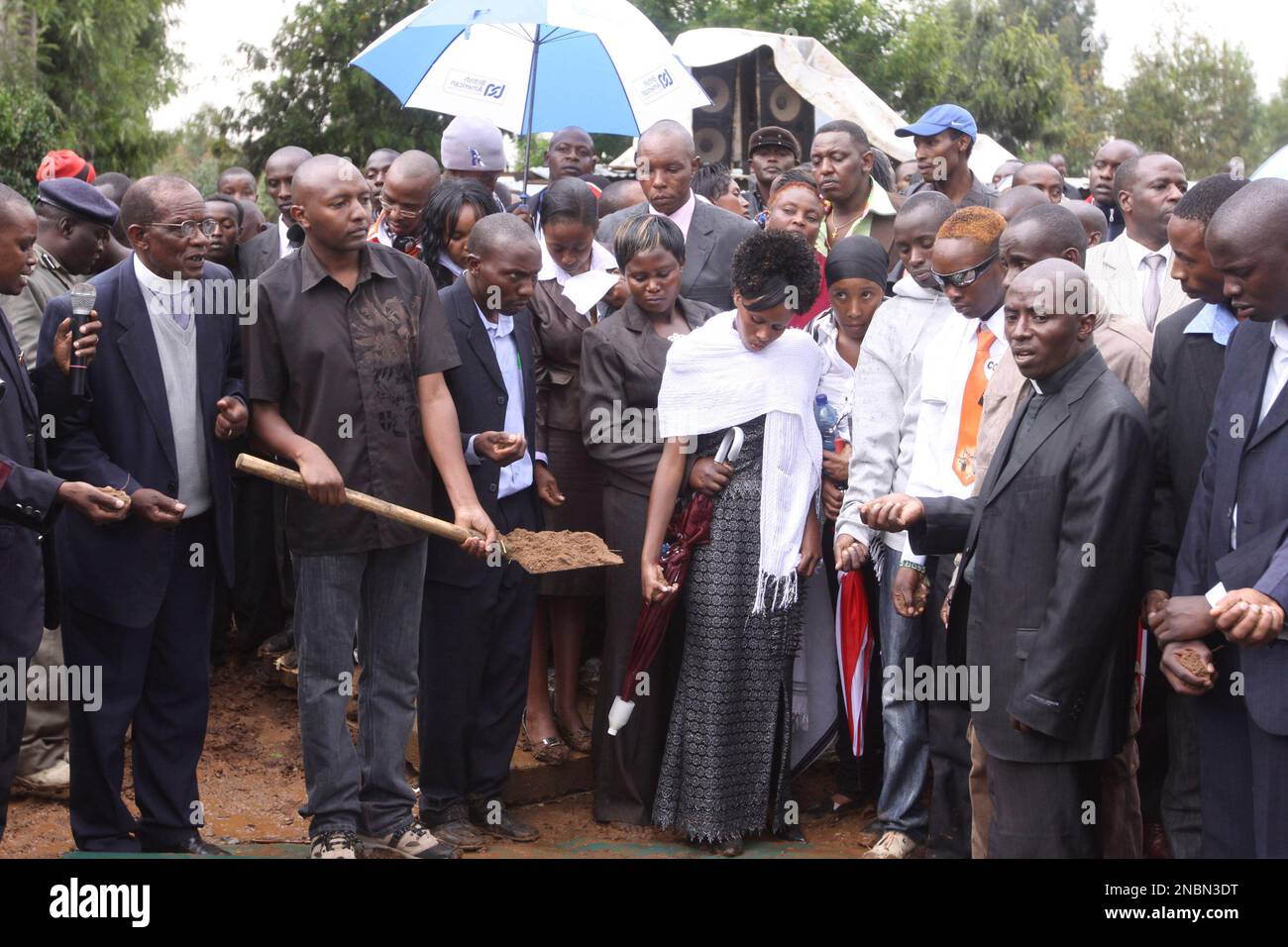 Preachers give Triza Njeri, the wife of Olympic marathon champion Samuel Wanjiru, soil to throw ...