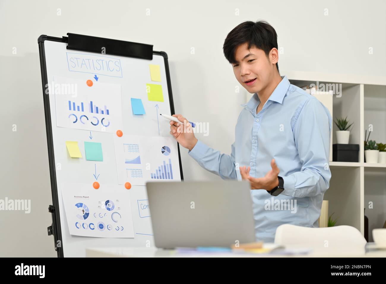 Confident businessman explaining business data on whiteboard during ...