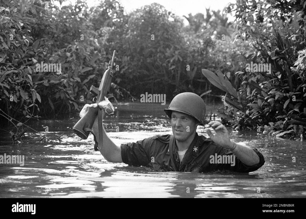 U.S. soldier crossing the river, wading neck deep in water through the ...