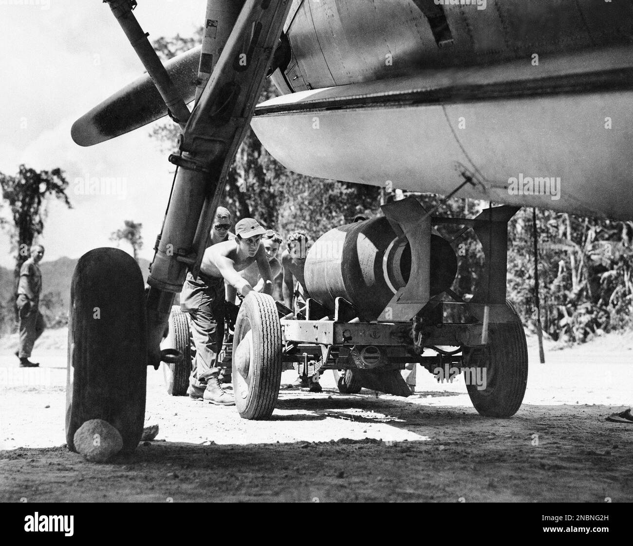 U.S. Marine ordnance men move a two-thousand pound bomb under the belly ...