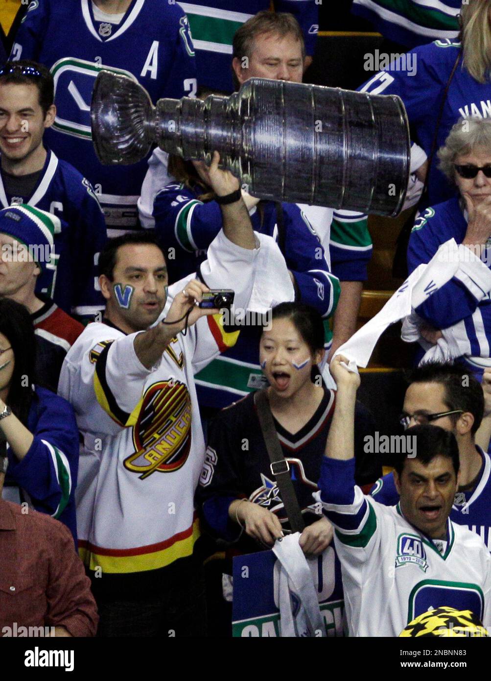Vancouver Canucks fans cheer as their team skates onto the ice for warm ...
