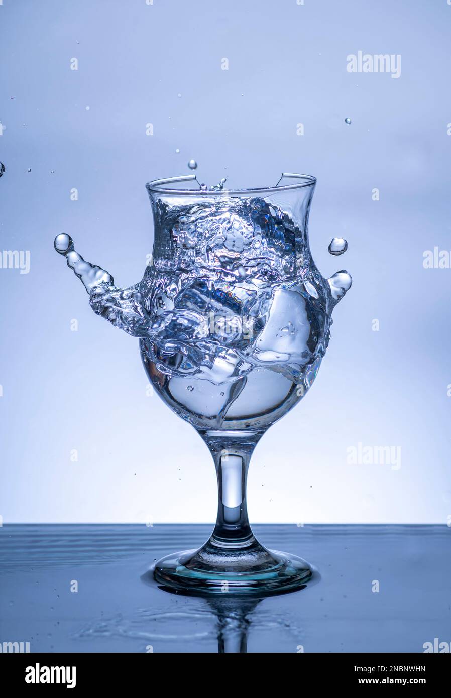 The image of pouring drinking water, into a broken glass, that makes ...