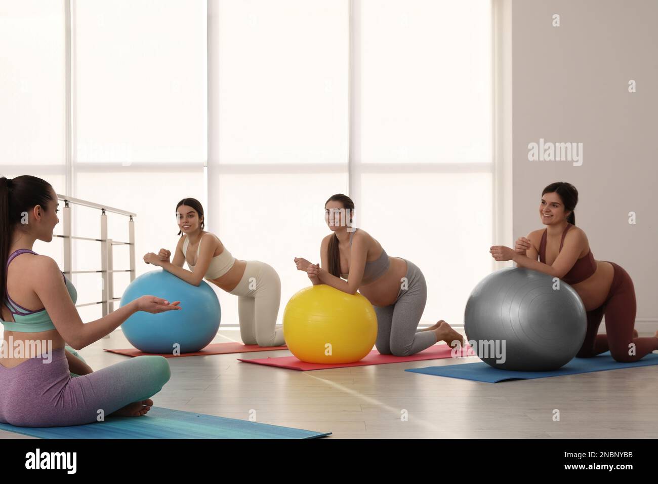 Trainer working with group of pregnant women in gym. Preparation for ...