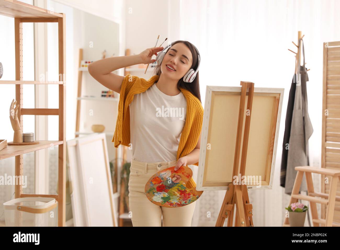 Beautiful young woman listening to music while drawing at home Stock ...