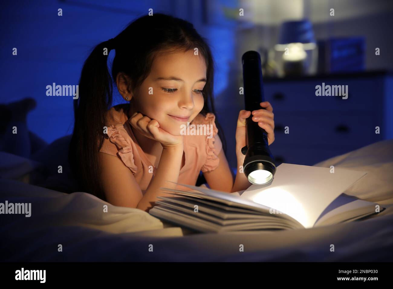 Little girl with flashlight reading fairy tale in dark bedroom Stock ...