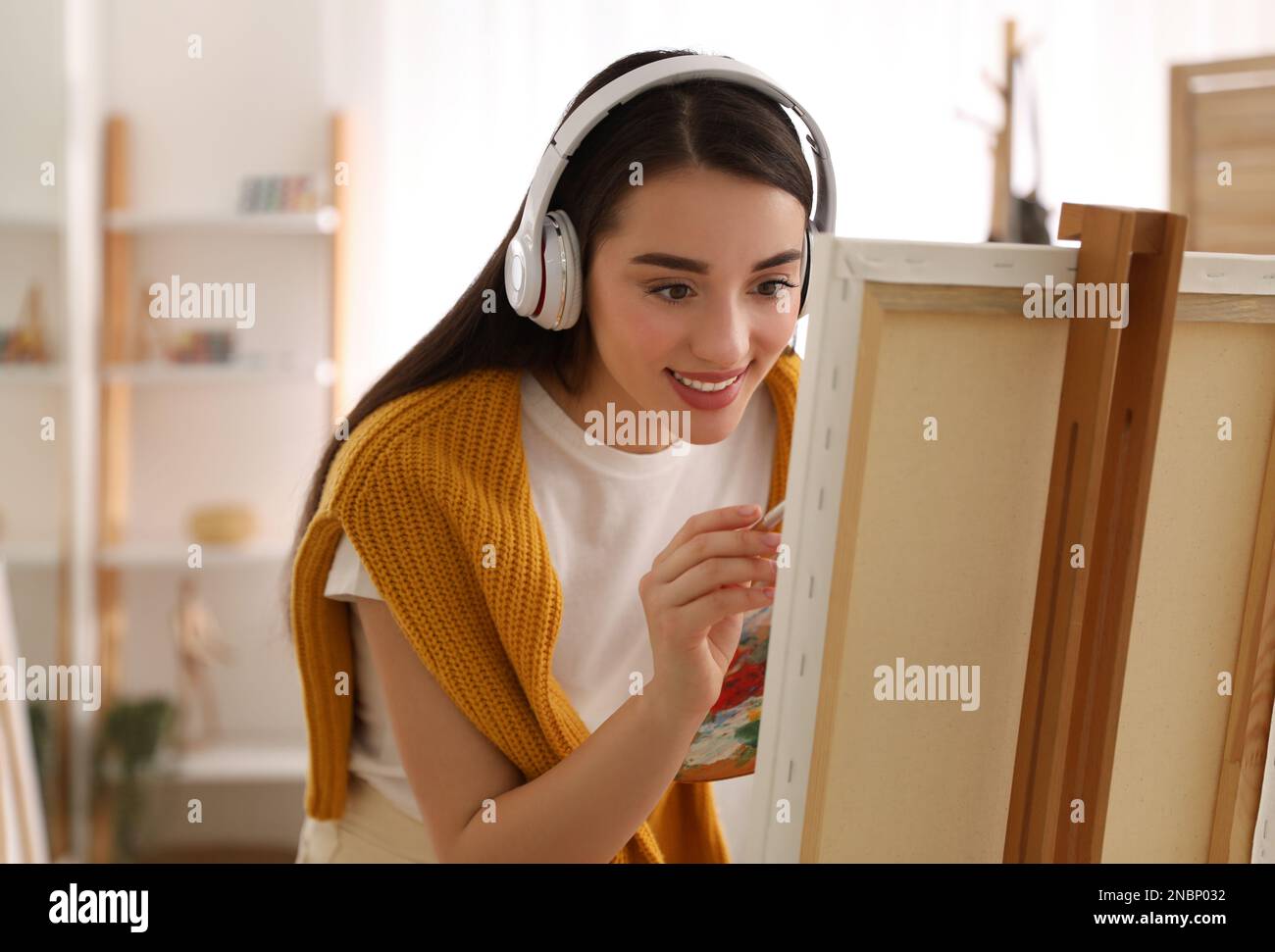 Beautiful young woman listening to music while drawing at home Stock ...