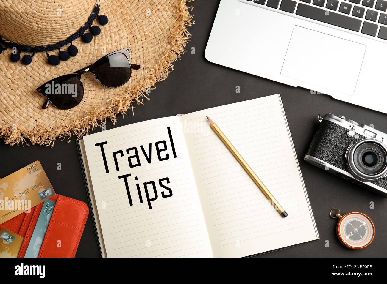 Flat lay composition with tourist items and notebook on black ...