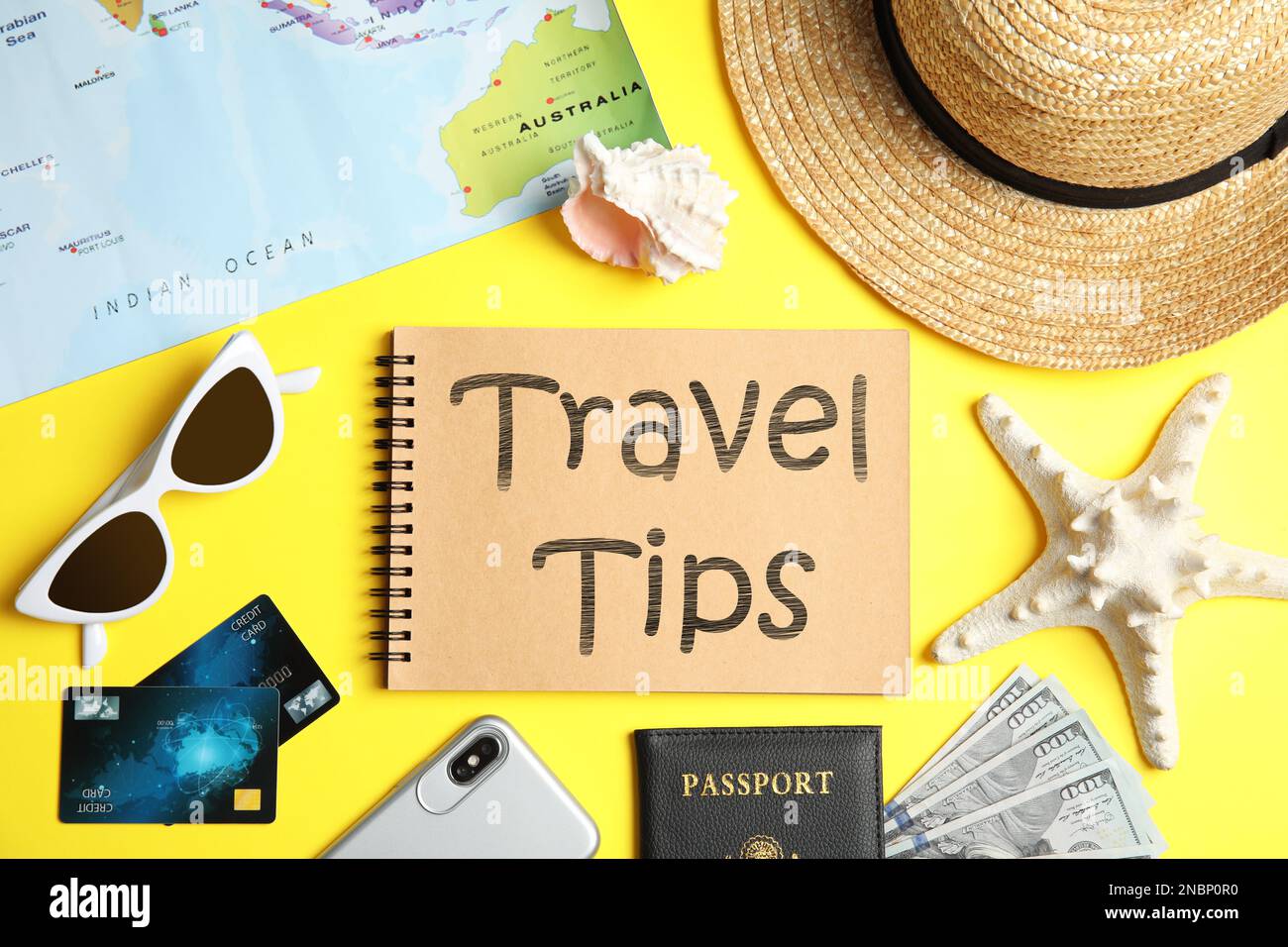 Flat lay composition with tourist items and notebook on yellow ...