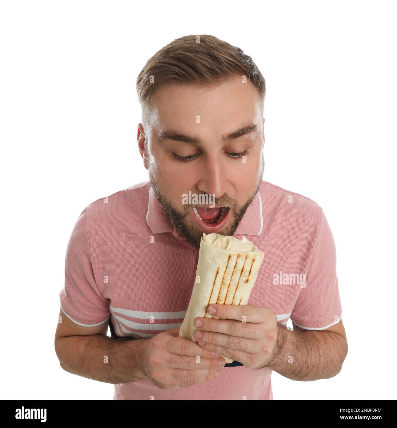 Young man eating delicious shawarma on white background Stock Photo - Alamy