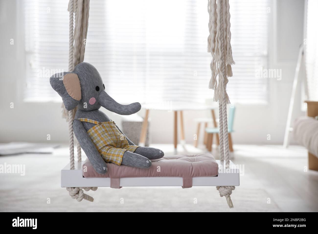 Beautiful swing with toy elephant in room. Stylish interior design ...