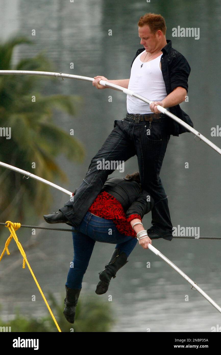 High-wire acrobats Delilah Wallenda, bottom, lowers her body as her son Nik Wallenda, top ...