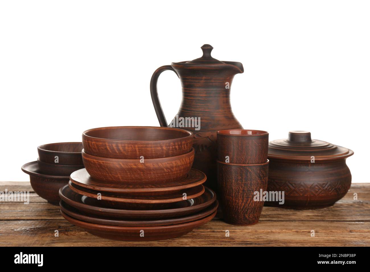 Different clay dishware on wooden table against white background Stock ...