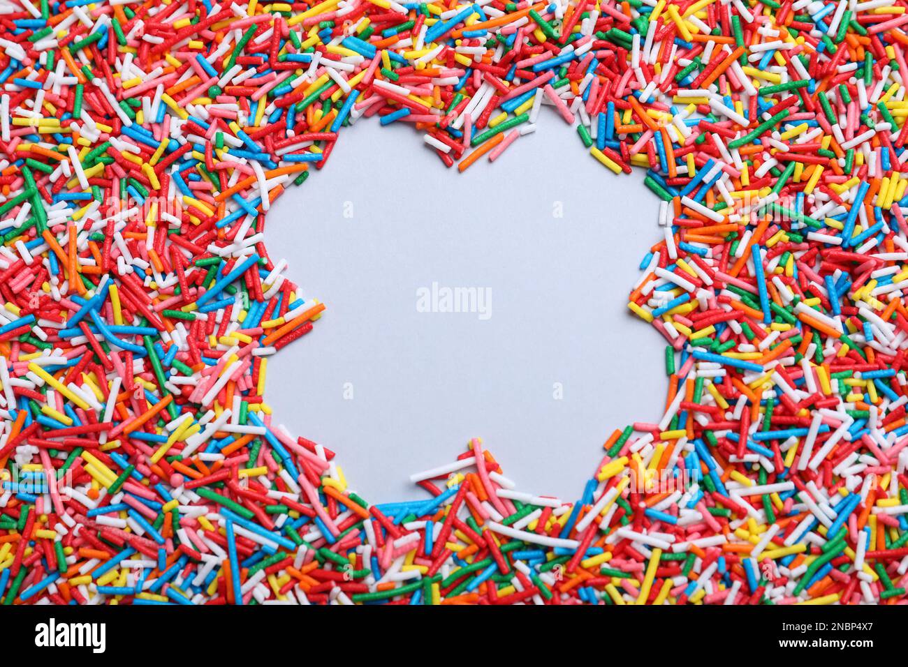 Frame of colorful sprinkles on light grey background, flat lay with ...