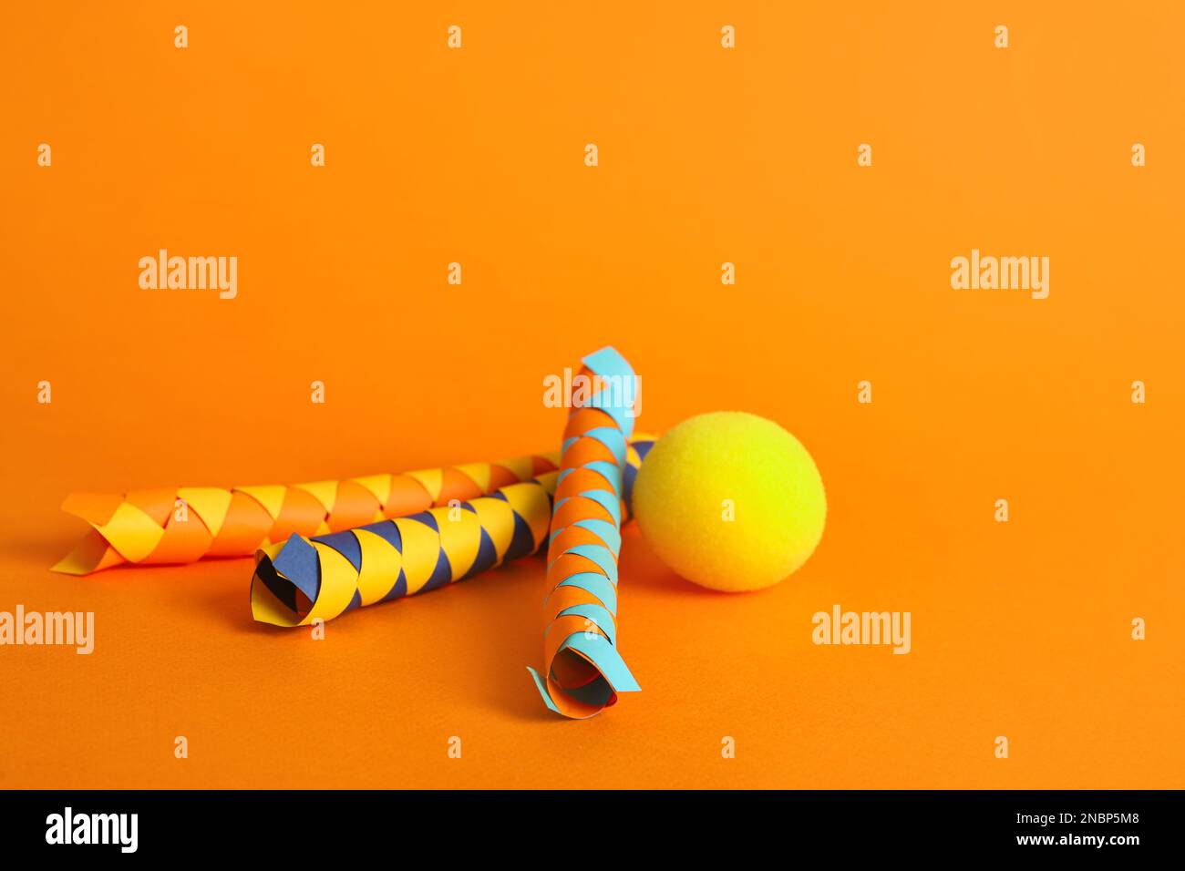 Chinese finger traps and clown nose on orange background Stock Photo ...